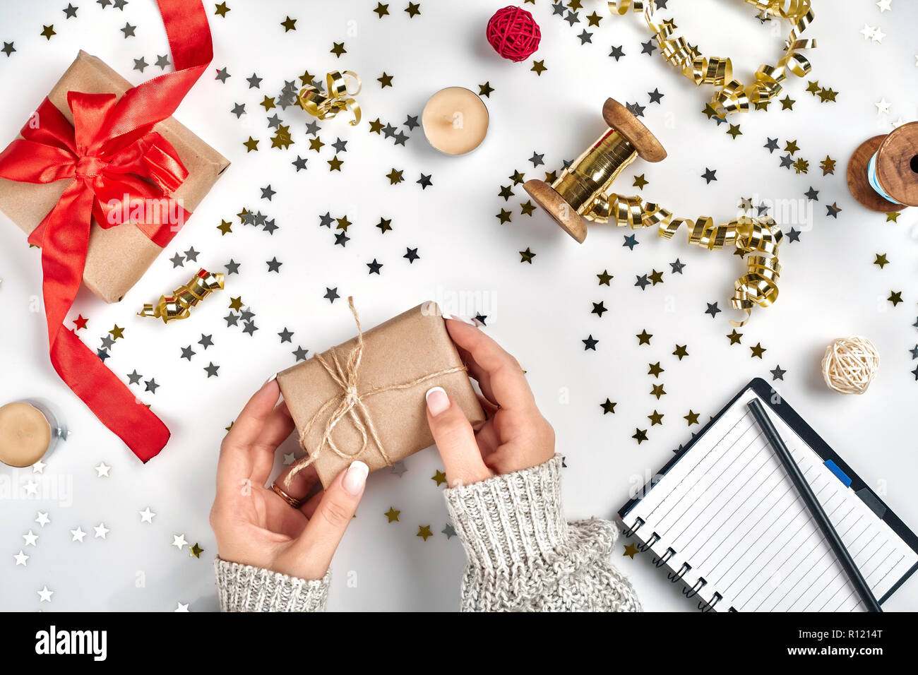 Female hands holding present on white background with delicate wavy ...