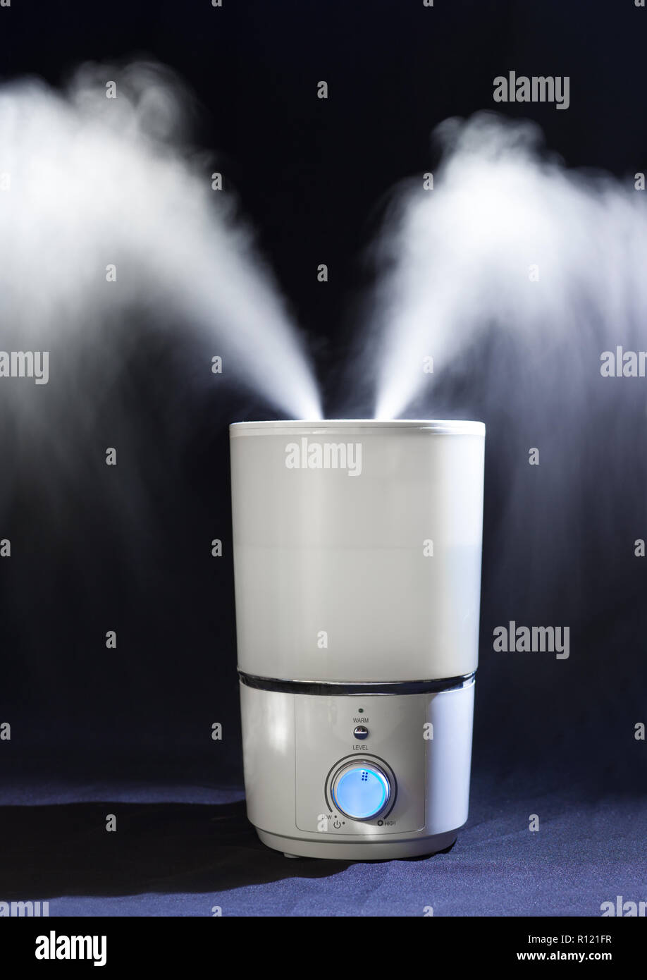 Humidifier spreading steam in a dark room Stock Photo - Alamy