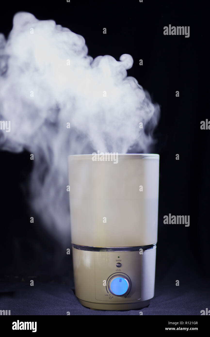 Humidifier spreading steam in a dark room Stock Photo - Alamy