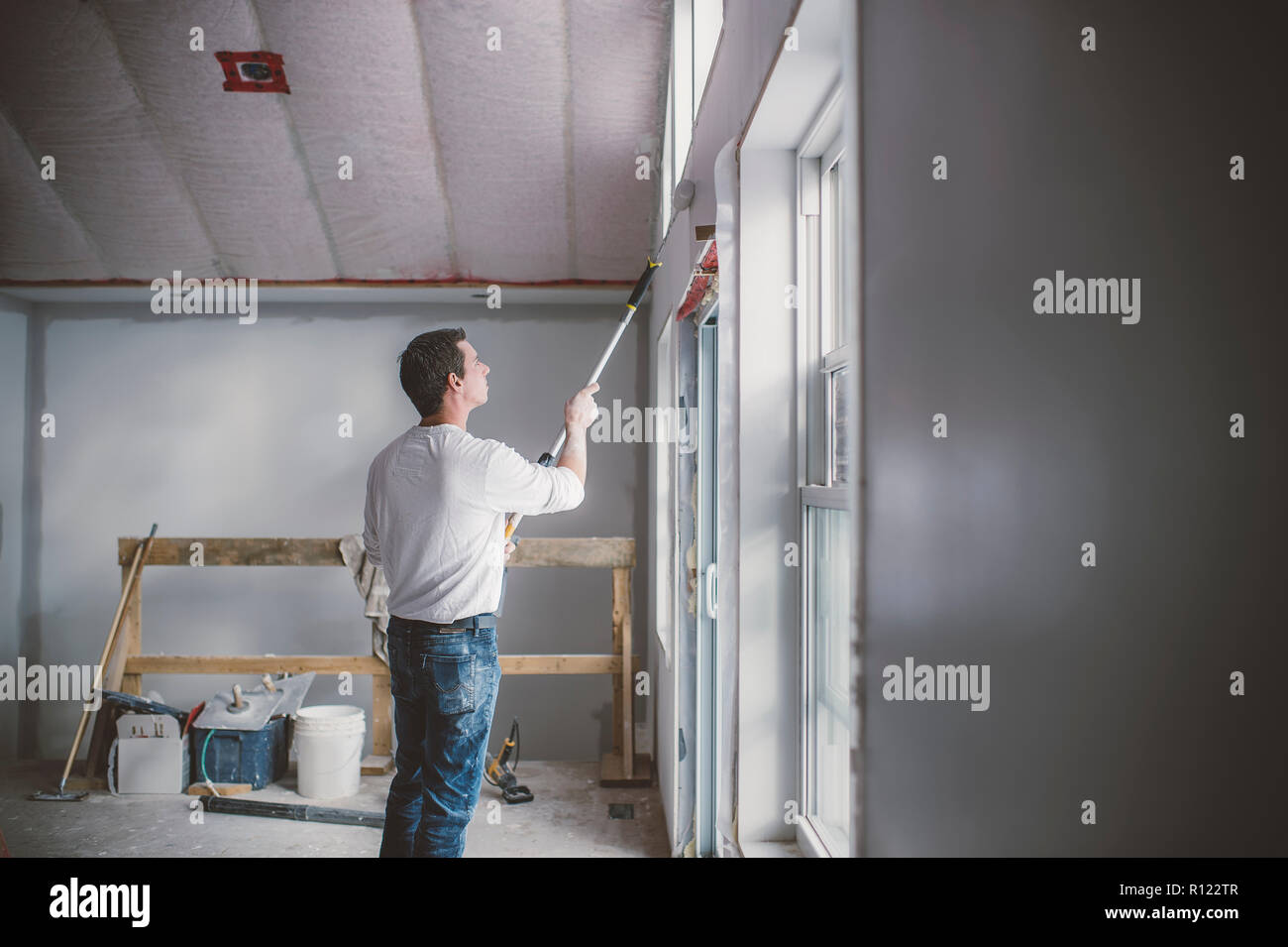 Painter decorator working inside building Stock Photo - Alamy