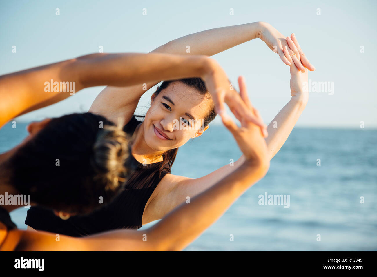 Friends doing exercises on beach Stock Photo - Alamy