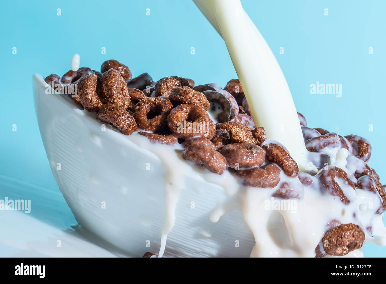 Milk stream pouring into a cup with chocolate flakes in the form of ...