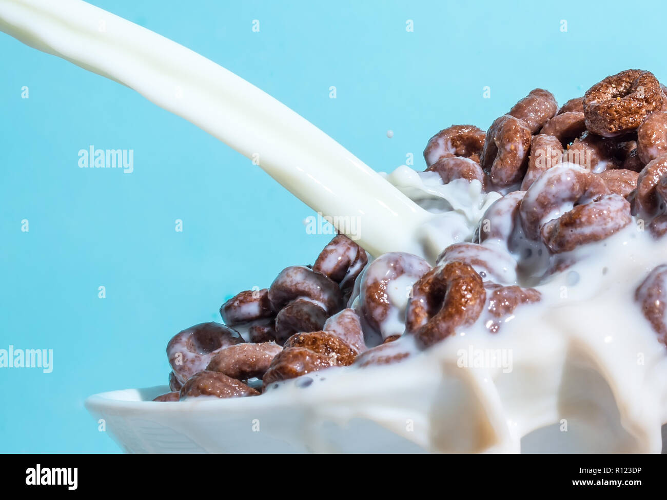Milk stream pouring into a cup with chocolate flakes in the form of ...