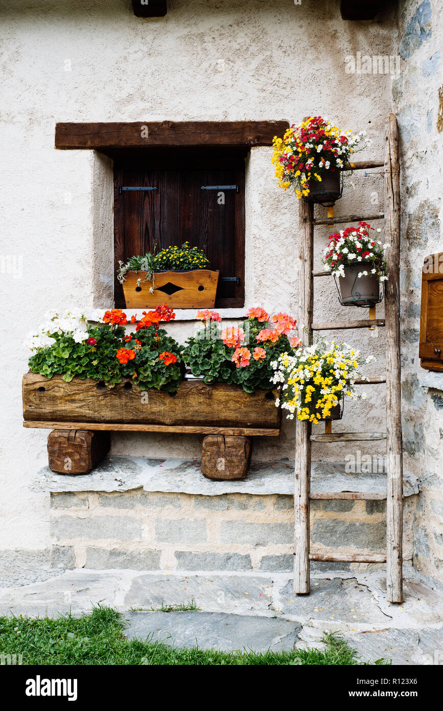 Mountain cabin window with wooden staircase with colorful geranium ...