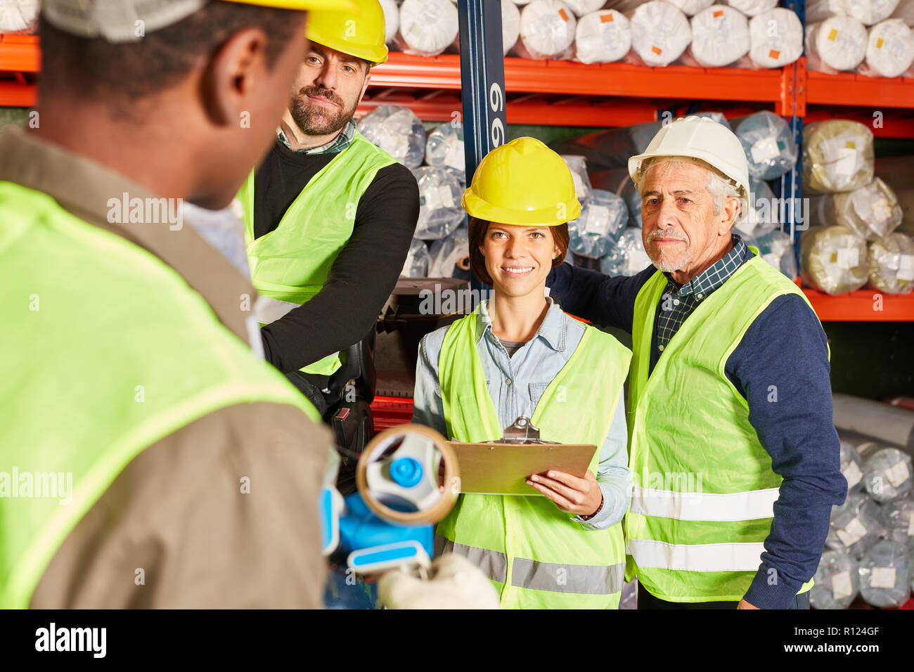Workers as a logistics team in the warehouse discuss a delivery ...