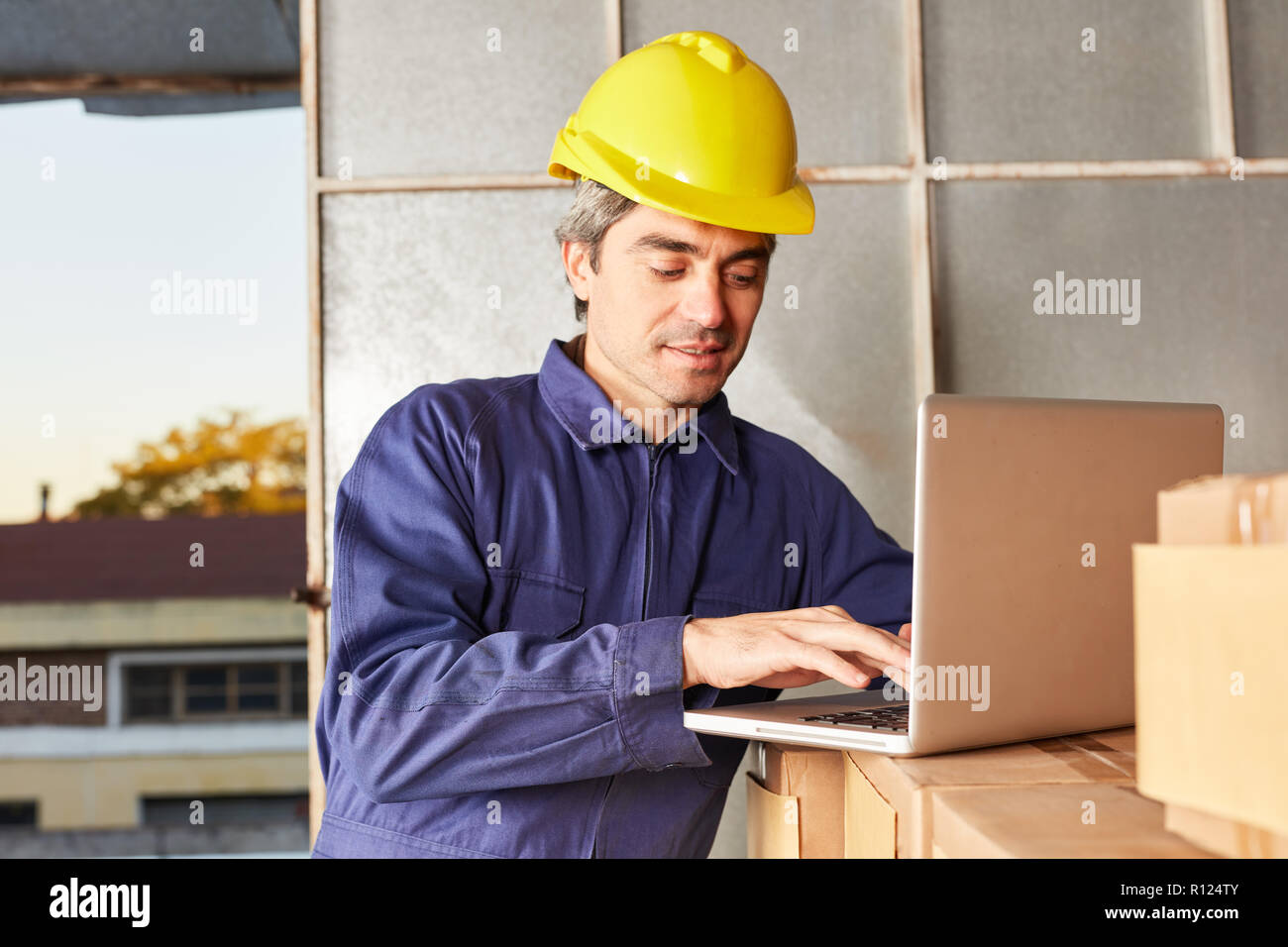 Logistics worker in online trade at laptop computer in logistics center ...