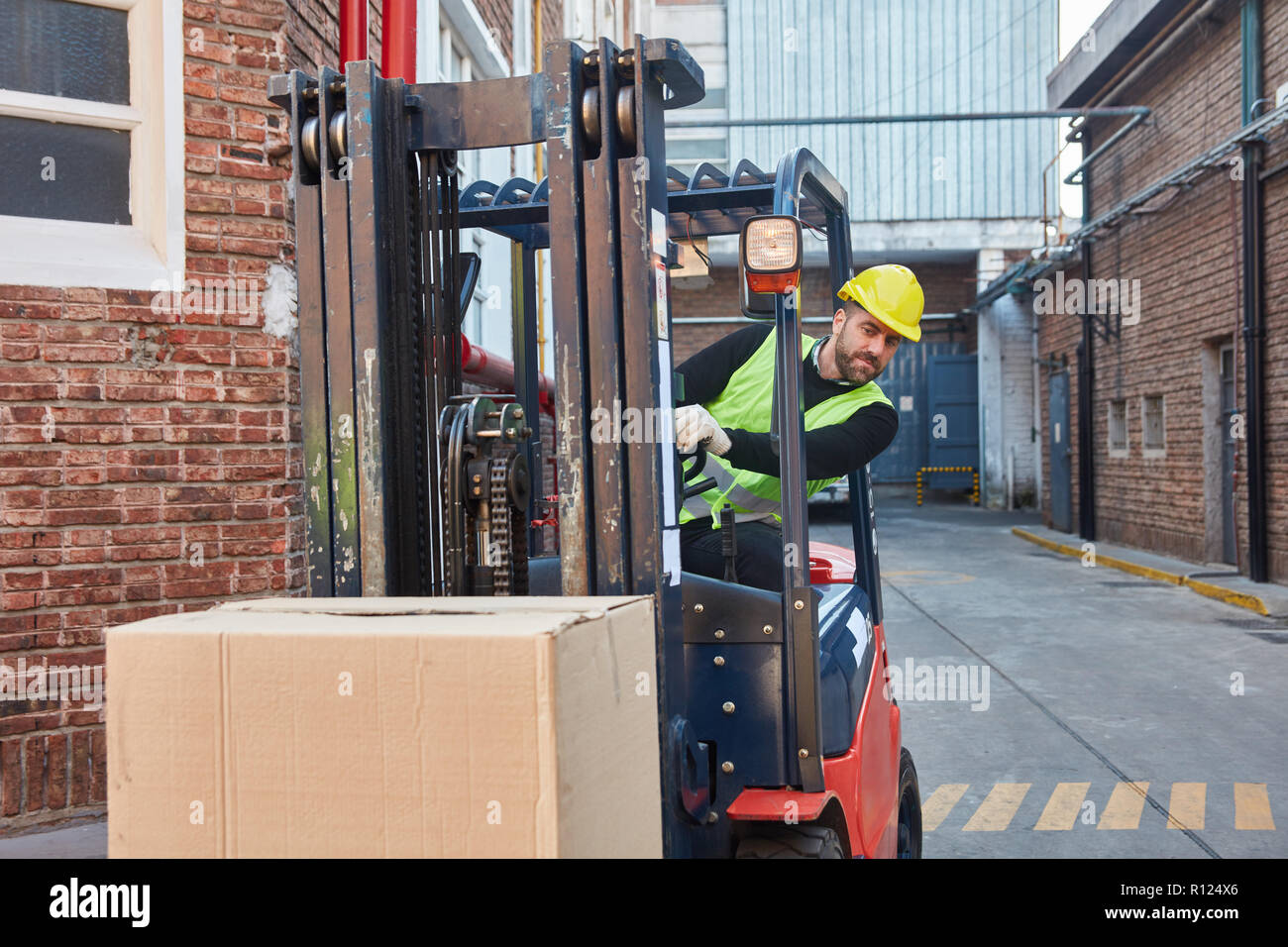 Logistics worker transports a package with the forklift for shipment ...