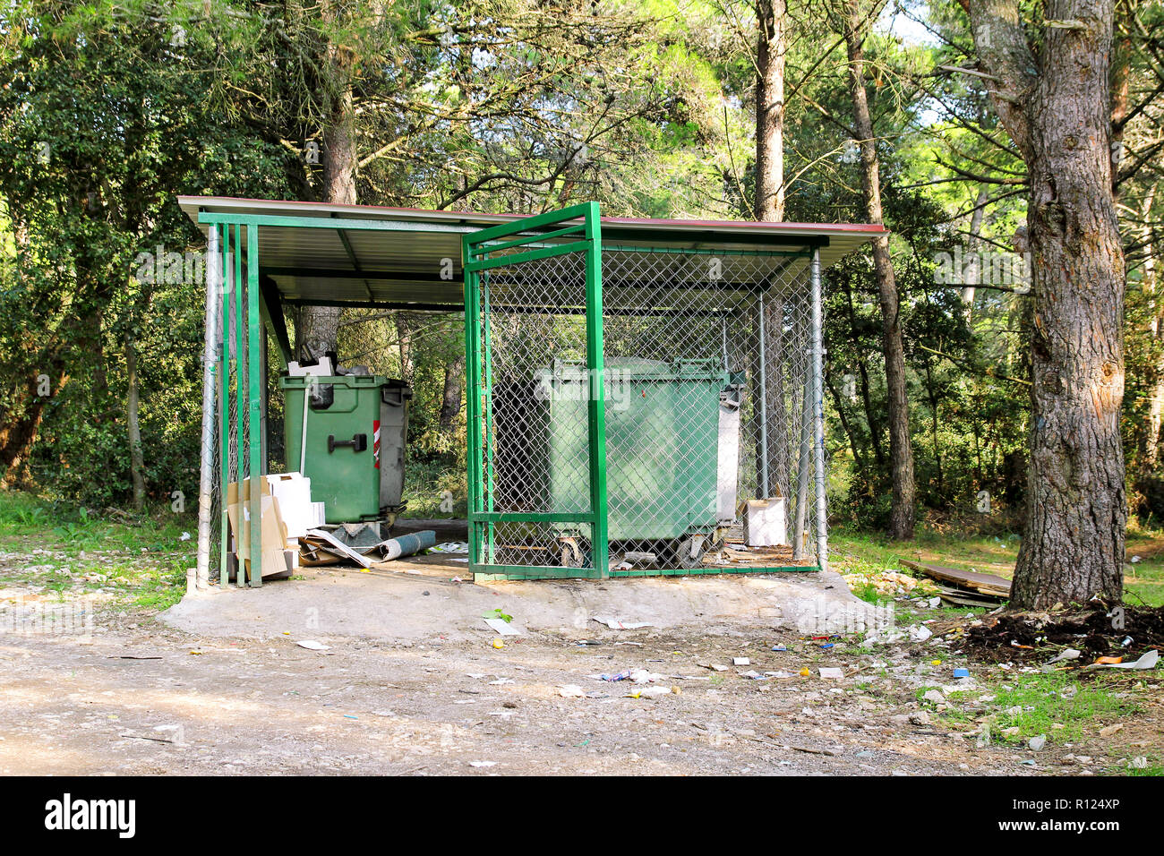 Garbage containers in fence cage / Orderly stowed garbage cans for ...