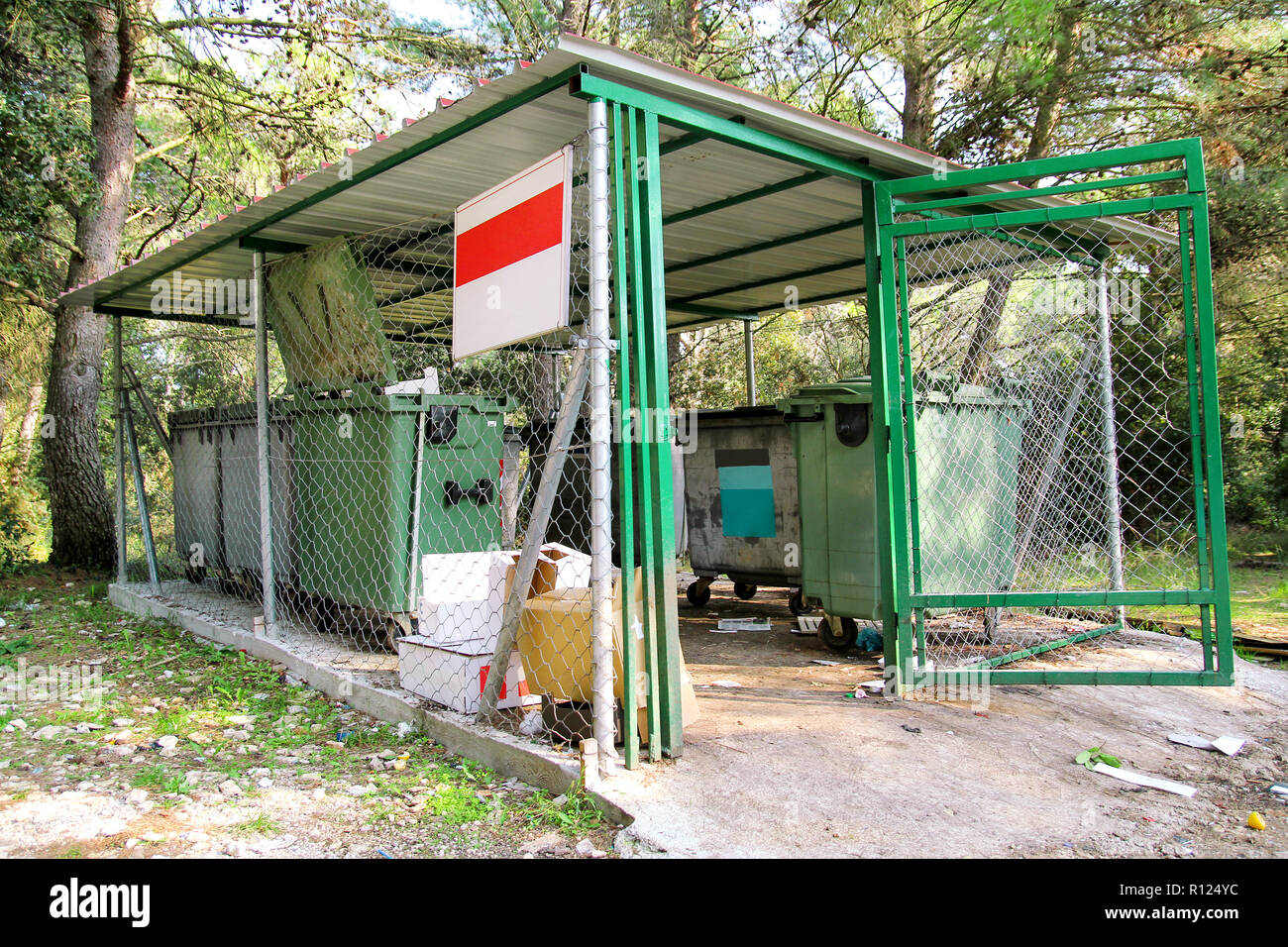 Garbage containers in fence cage / Orderly stowed garbage cans for ... Garbage containers in fence cage / Orderly stowed garbage cans for ...