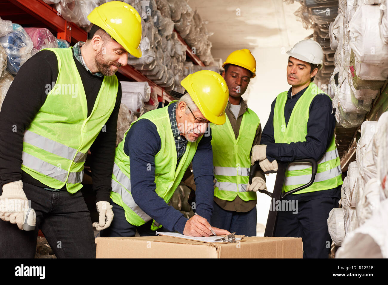 Logistics team and order pickers prepare a delivery in the warehouse ...