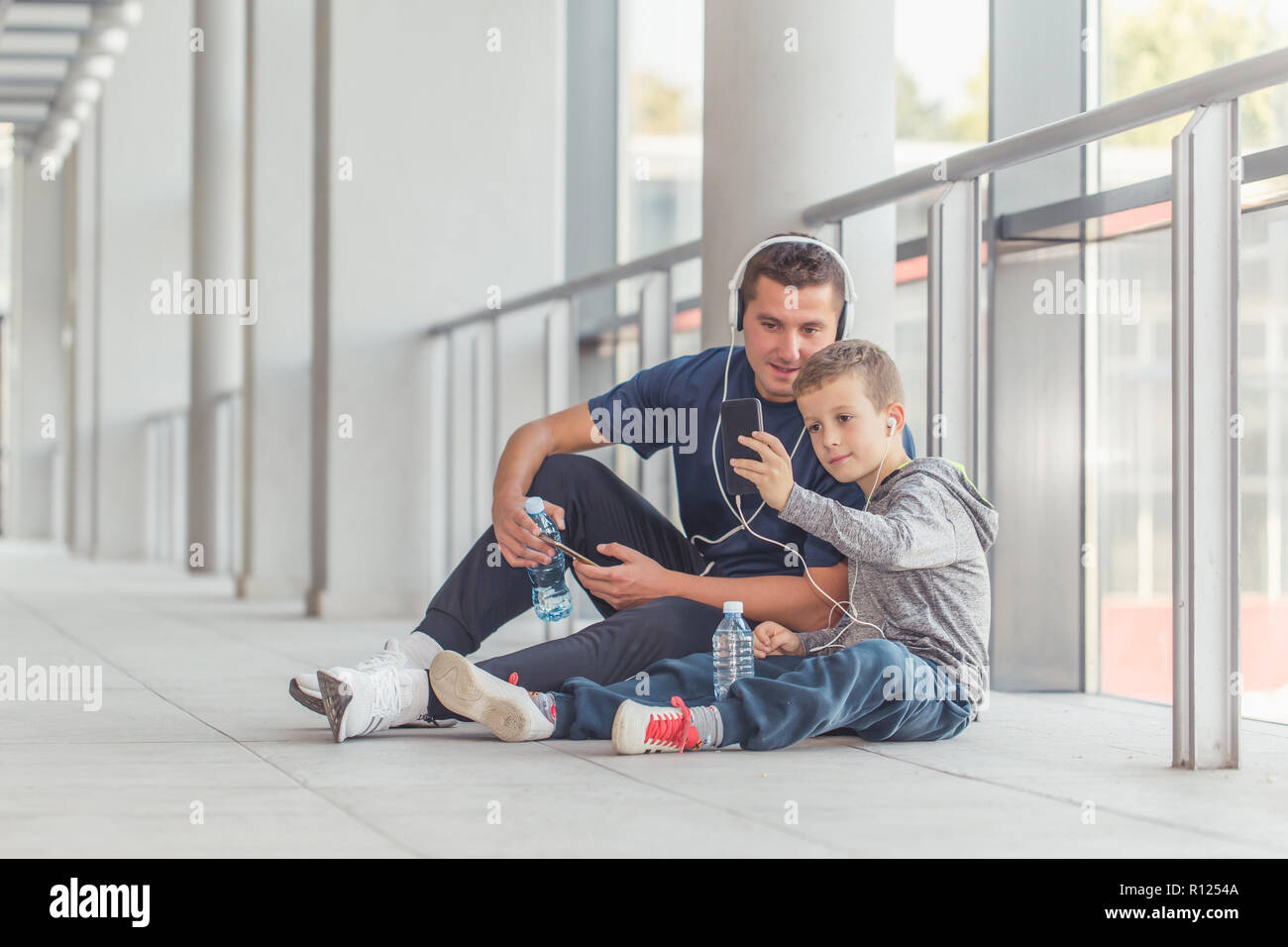 Little boy and his father taking a break and listening to the music ...