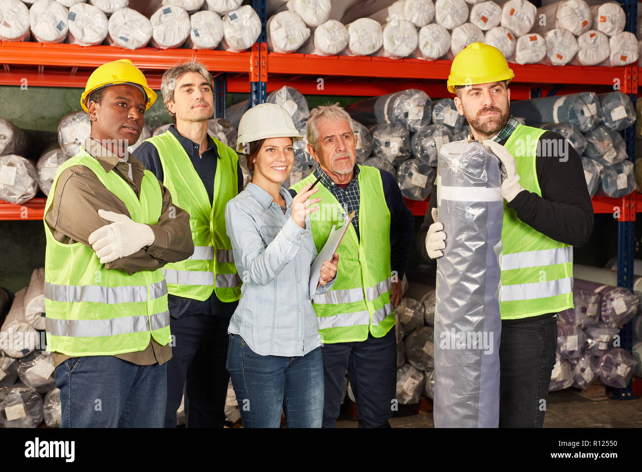 Logistics team with young woman as a trainee in the warehouse together ...