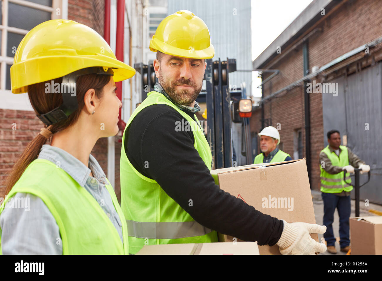 Logistics workers of a freight forwarder carry packages as delivery ...