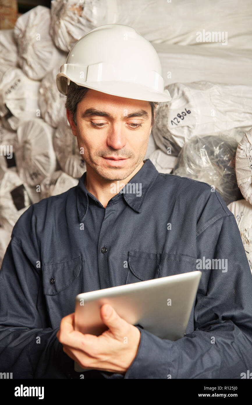 Warehouse worker using tablet computer checks inventory during ...