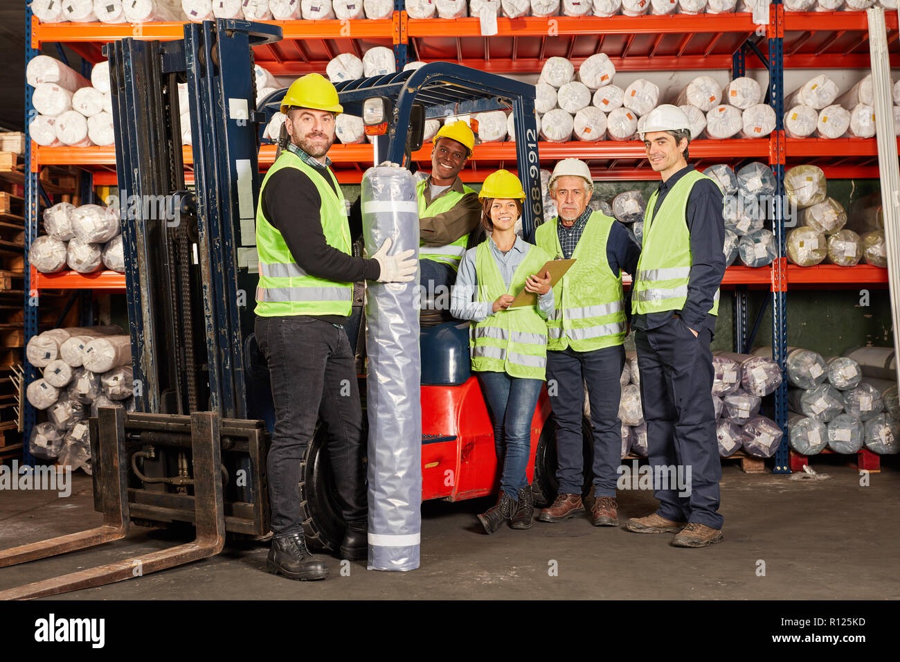 Successful logistics team with forklift in warehouse in shipping center ...