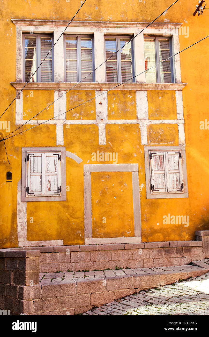Old yellow facade / Classic vintage wood windows at the yellow concrete ...