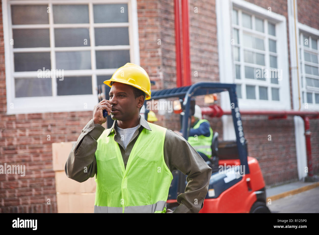 Logistics worker with radio coordinates delivery in front of the ...