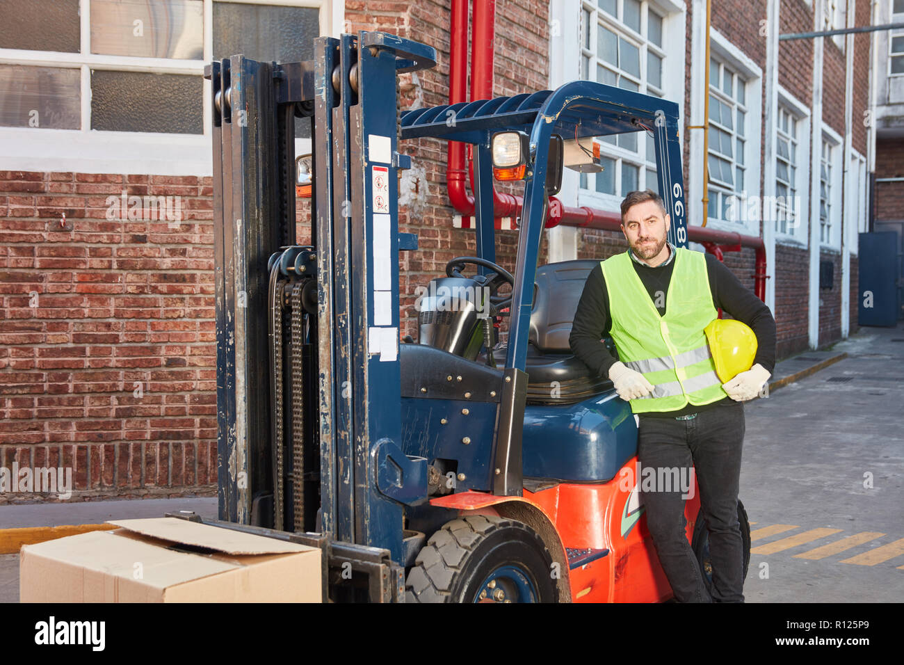 Satisfied forklift driver with his forklift before the freight ...
