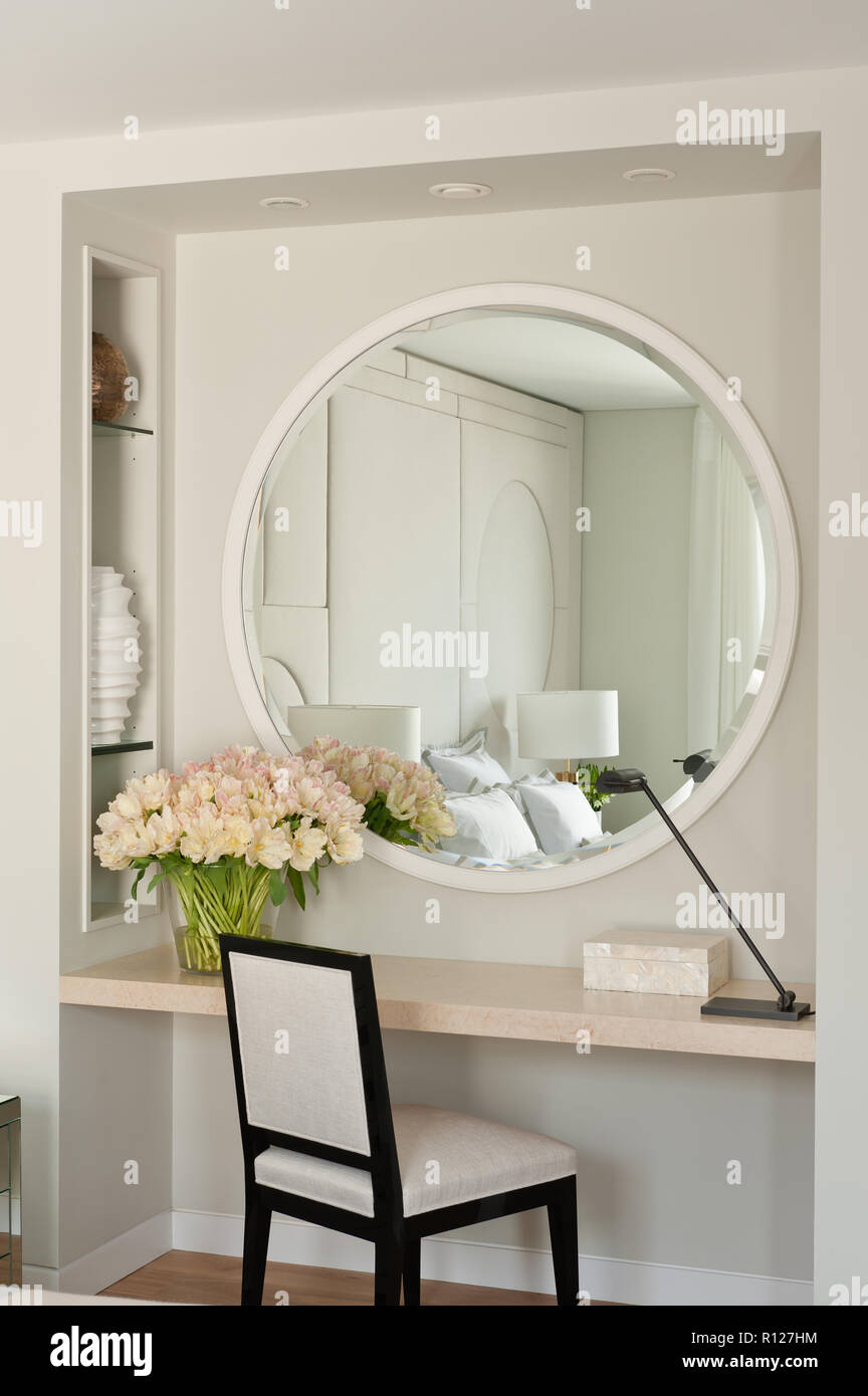 Recessed desk with flowers and circular mirror Stock Photo - Alamy
