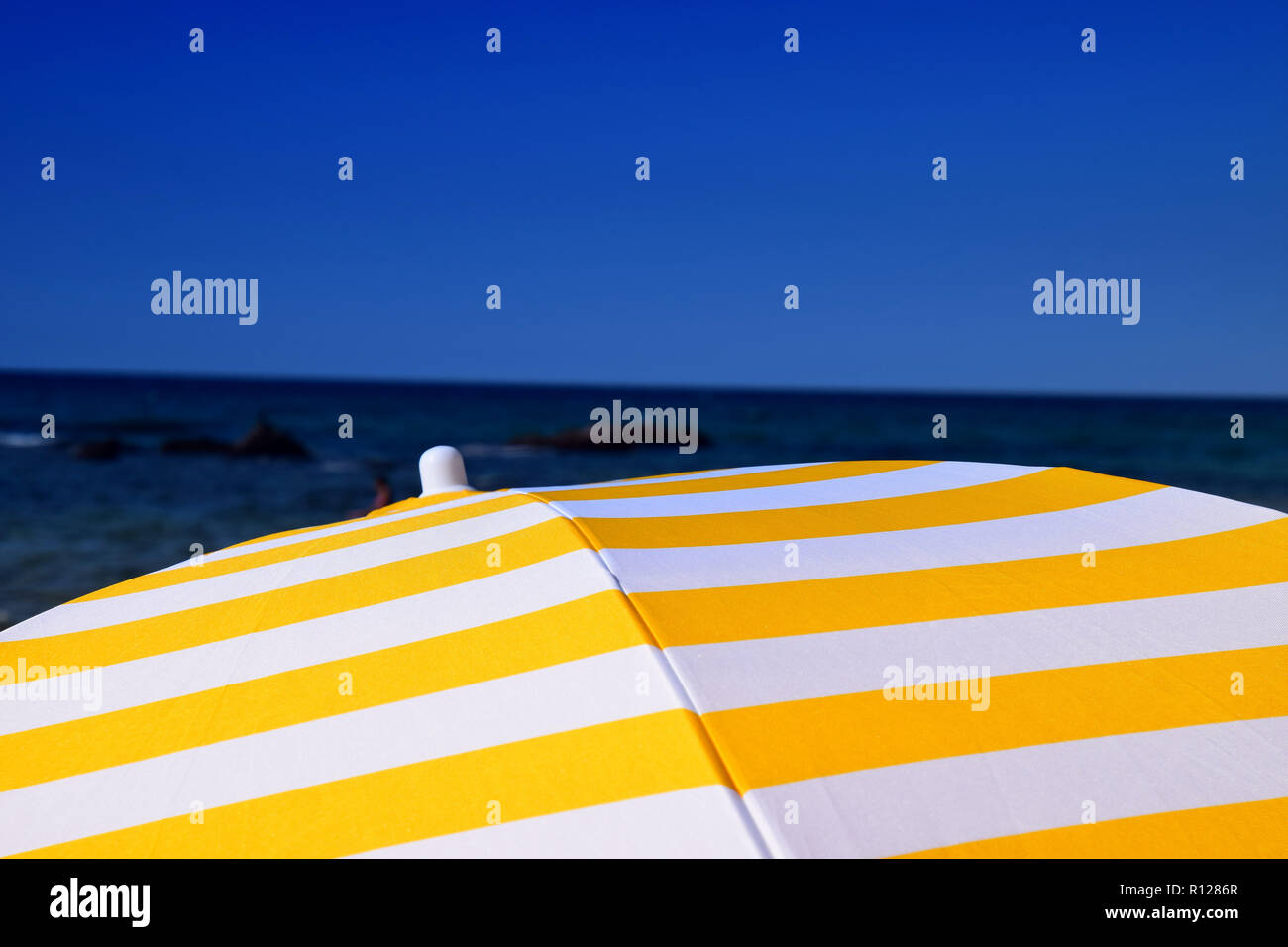 hot summer scene on mediterranean beach, yellow and white striped ...