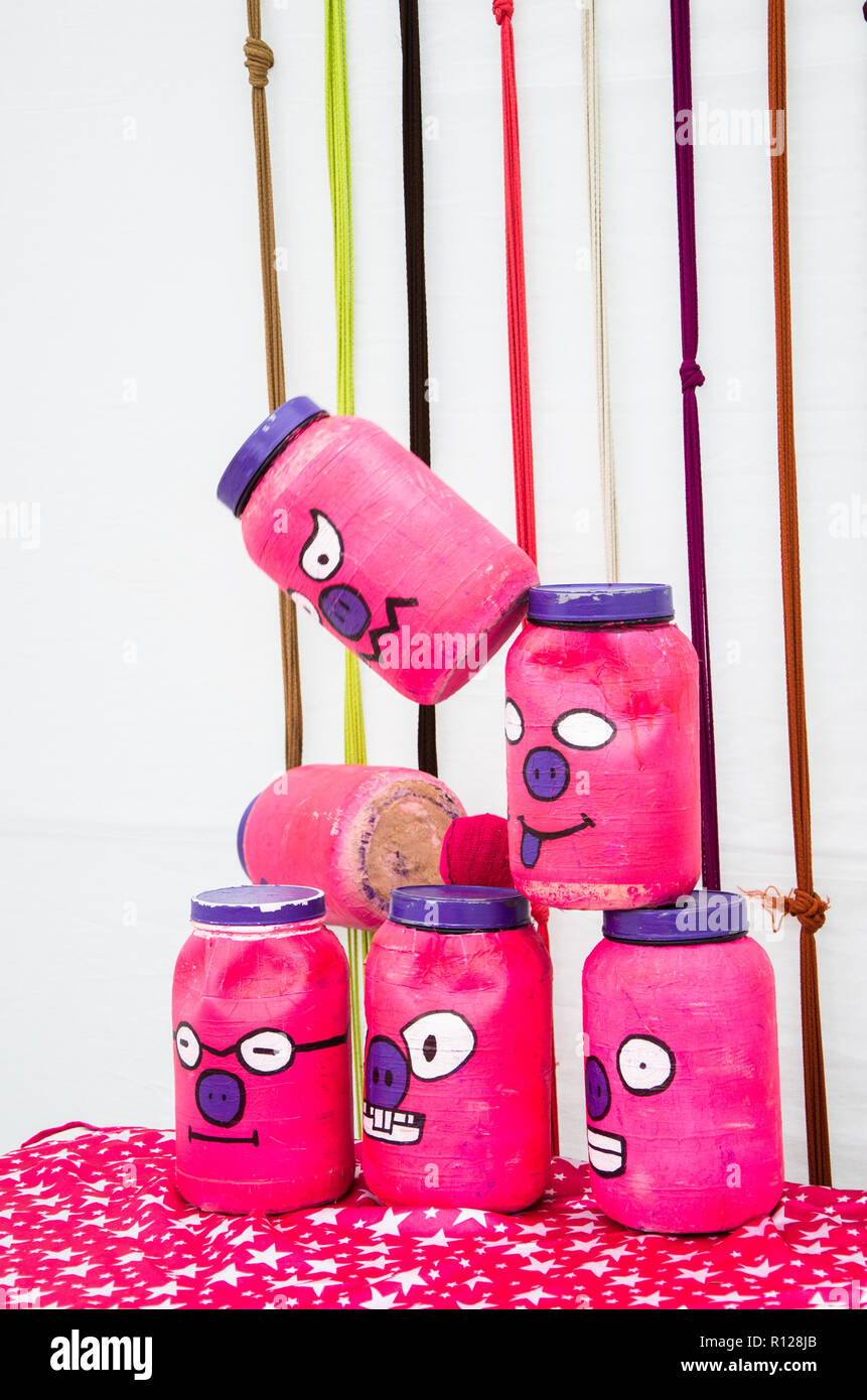 A pyramid of plastic containers with funny faces to throw balls on a ...