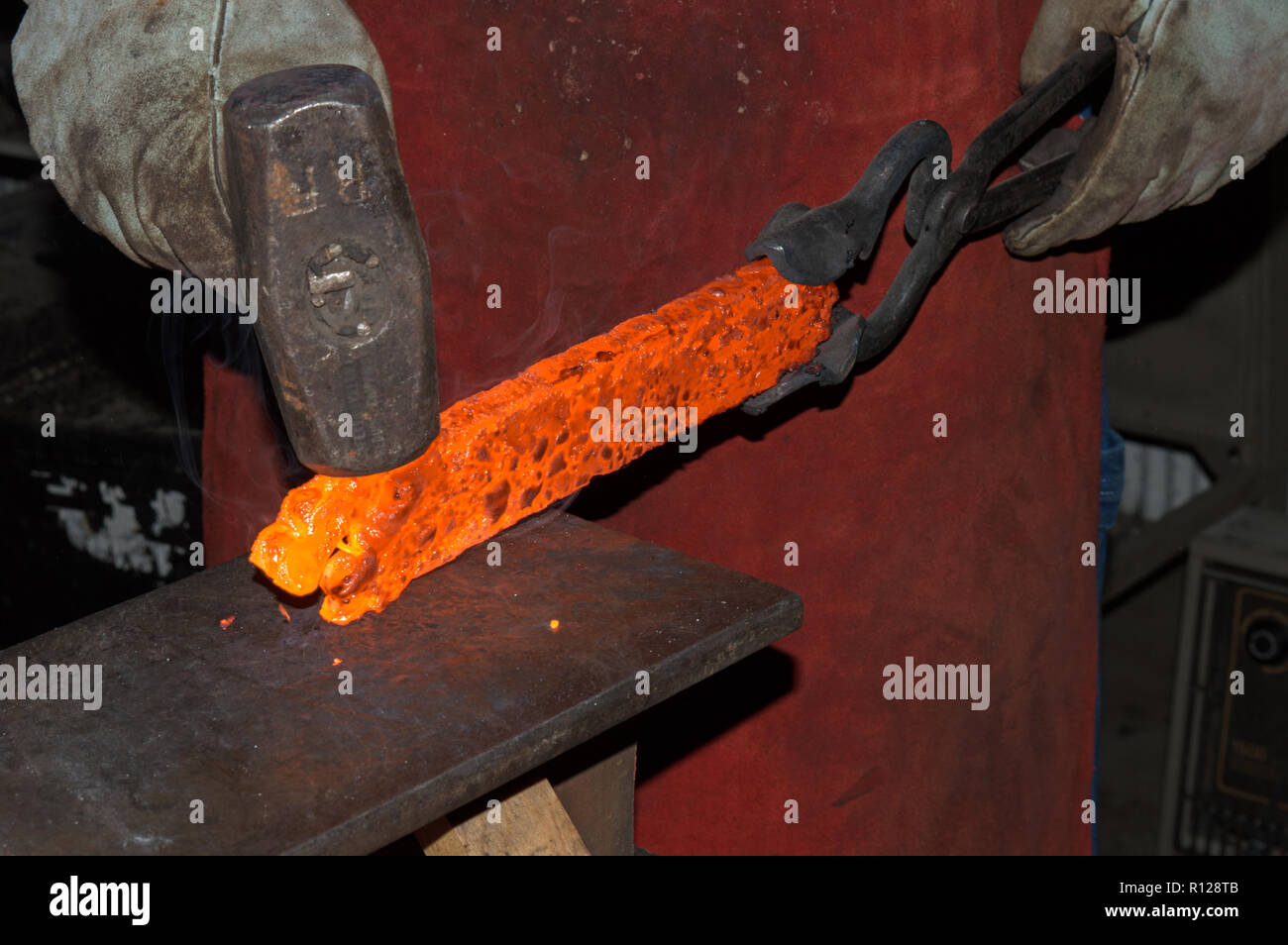 Red hot from the intense heat of a forge, the blacksmith skillfully ...
