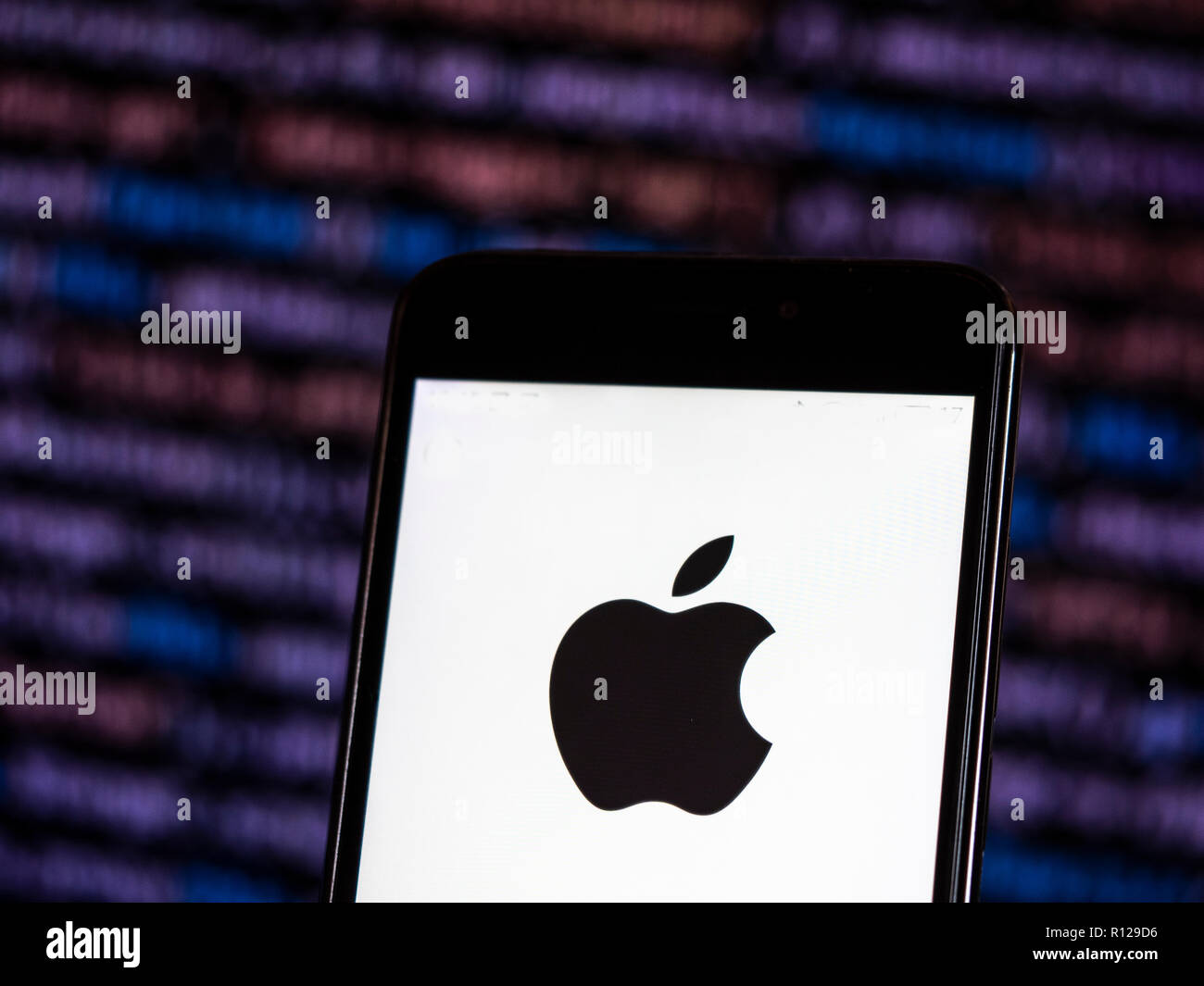 Apple logo seen displayed on a smart phone with a digital background ...