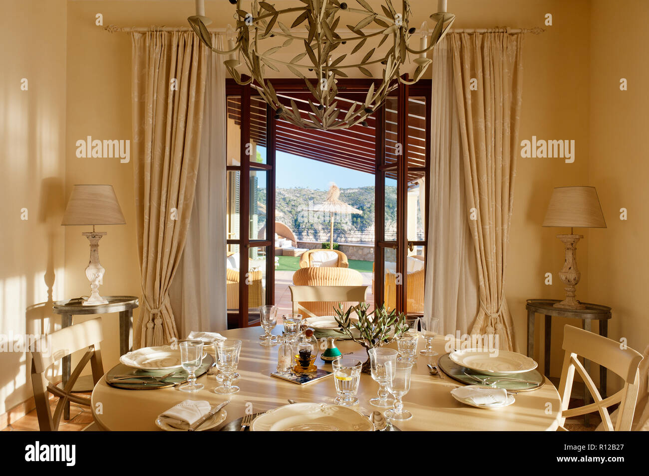 Yellow toned dining room with set table Stock Photo - Alamy