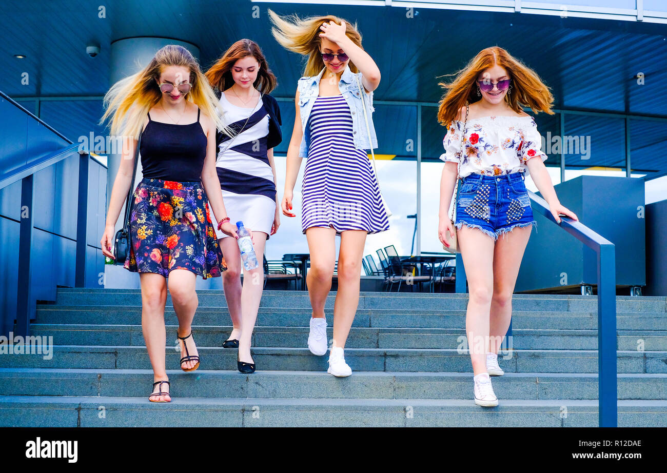 Friends coming down staircase Stock Photo - Alamy