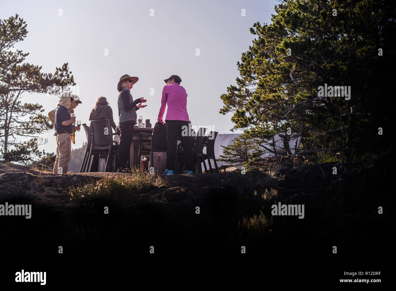 Friends talking at dinner on cliff top, Johnstone Strait, Telegraph ...