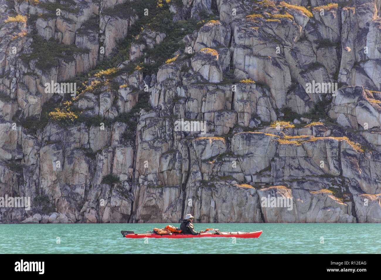Man kayaking near cliff, Narsaq, Vestgronland, Greenland Stock Photo ...