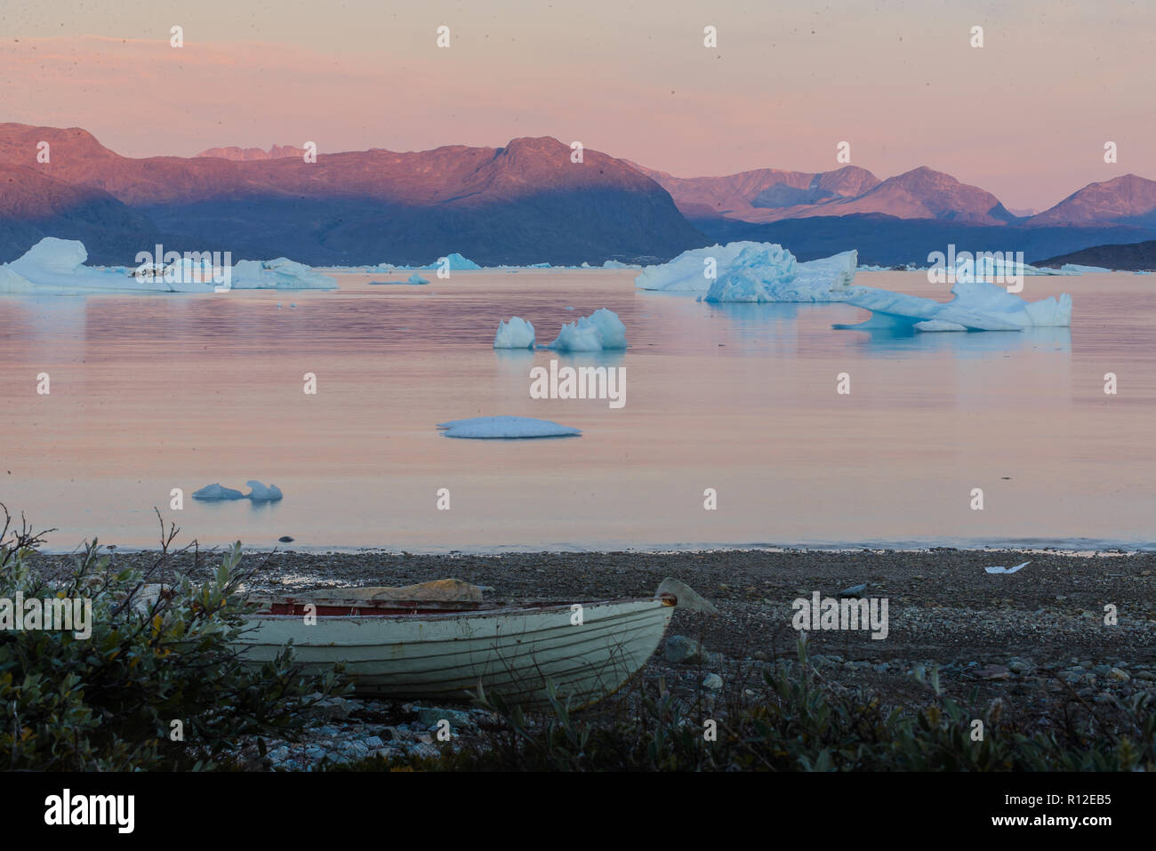 Boat on beach, icebergs and mountain ranges in background, Narsaq ...