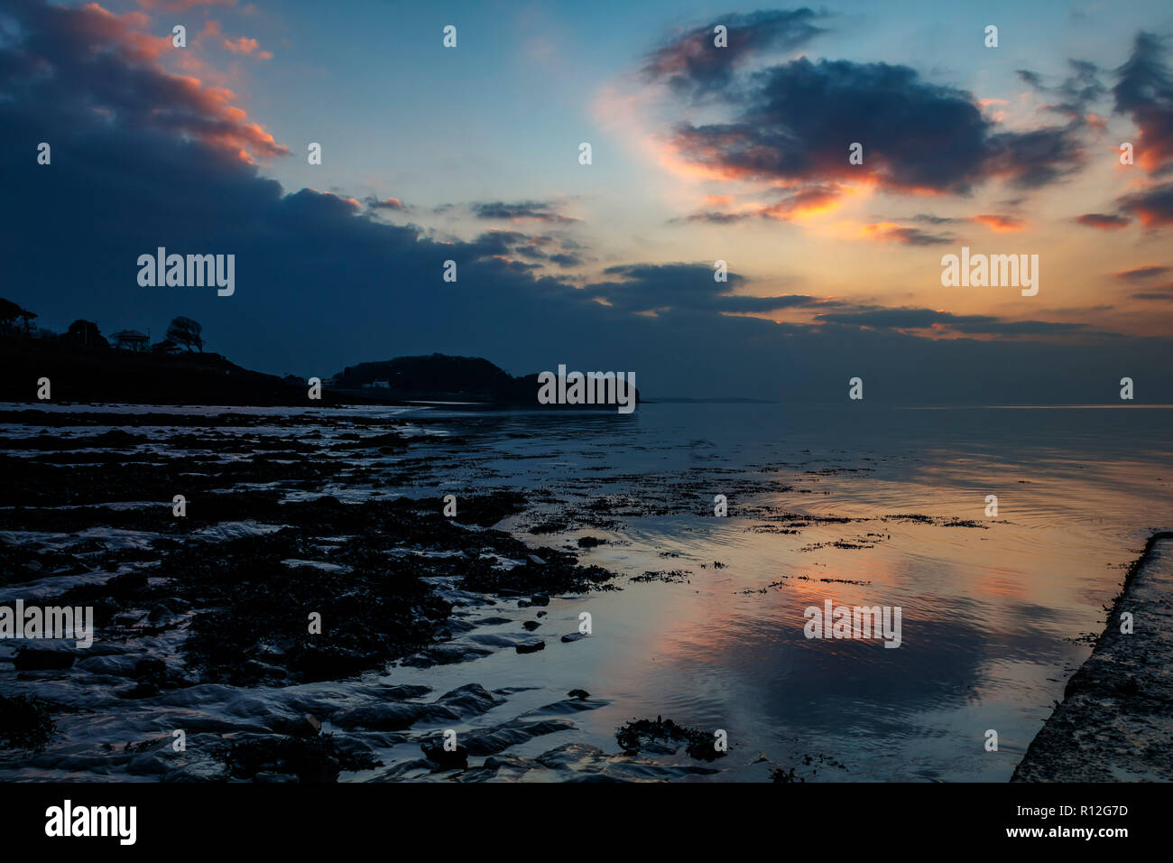 Sunset reflection and mud Stock Photo - Alamy