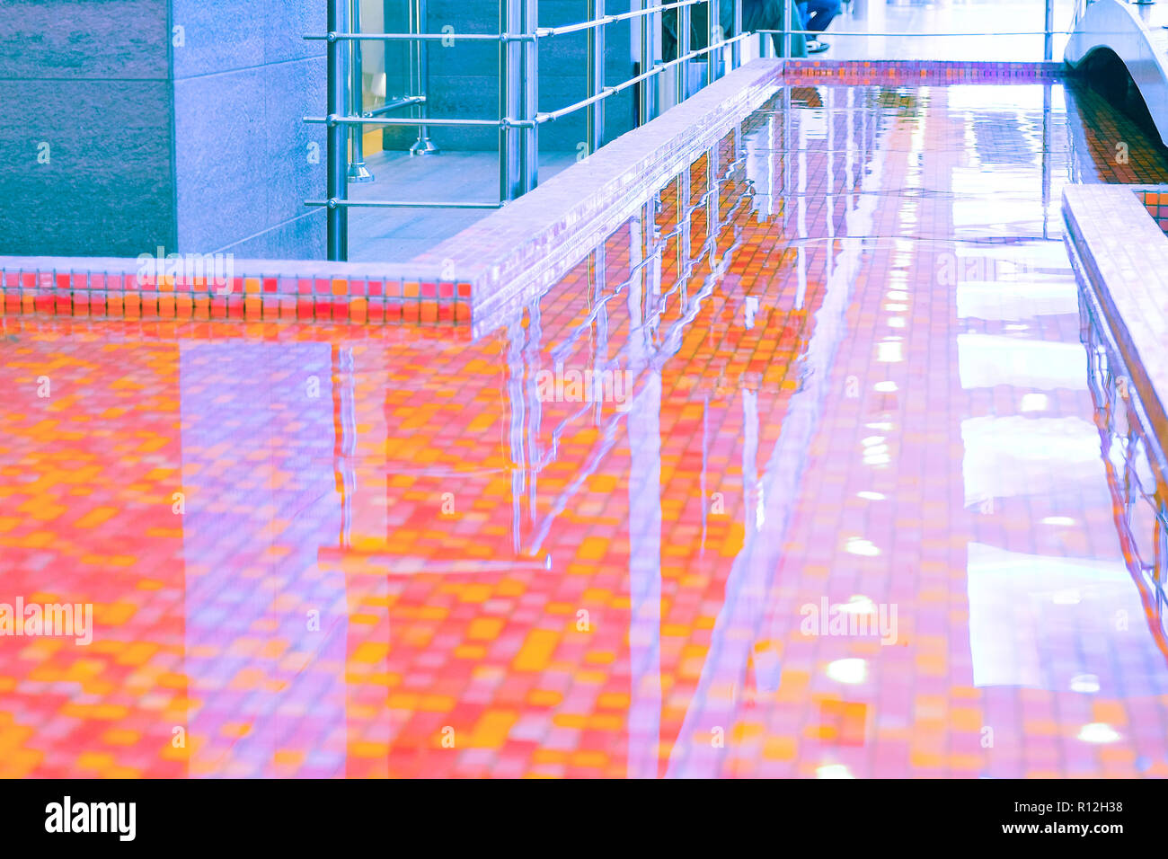 water in the pool with red-orange decorative tiles Stock Photo - Alamy