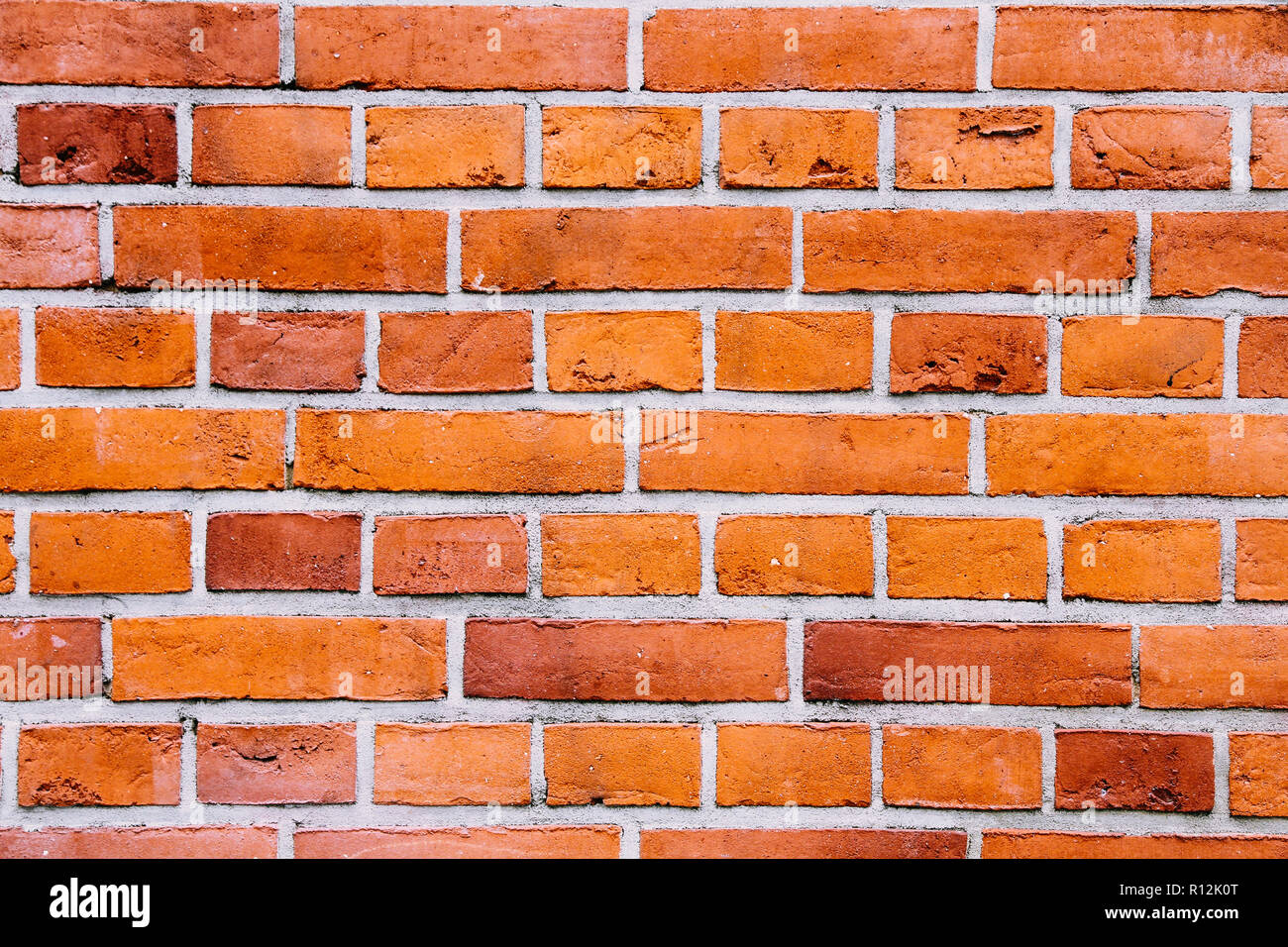 Red orange brick wall with grey cement between the bricks detail as ...