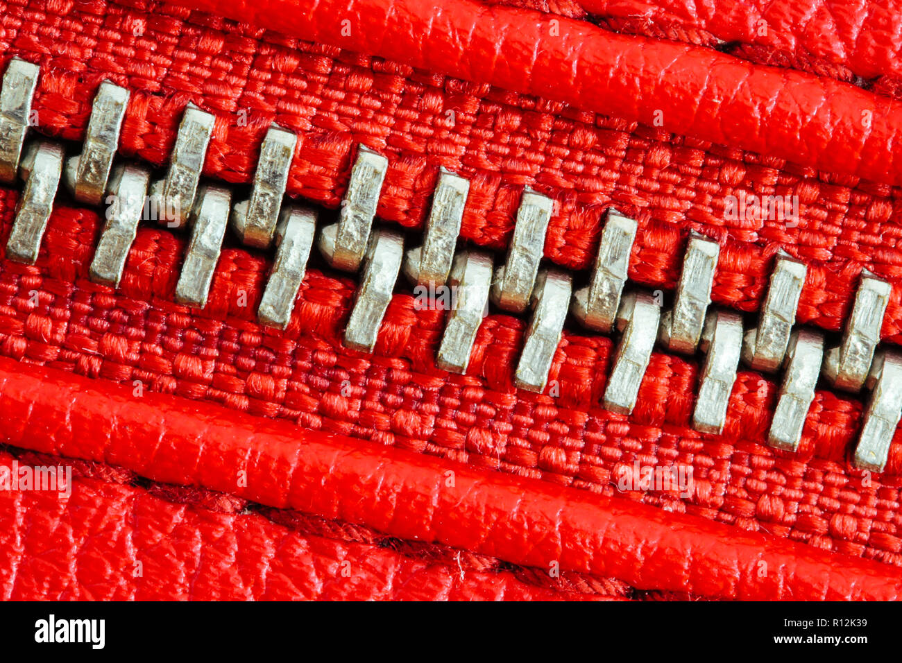 Diagonal zipper tightly closed binding together two layers of red ...