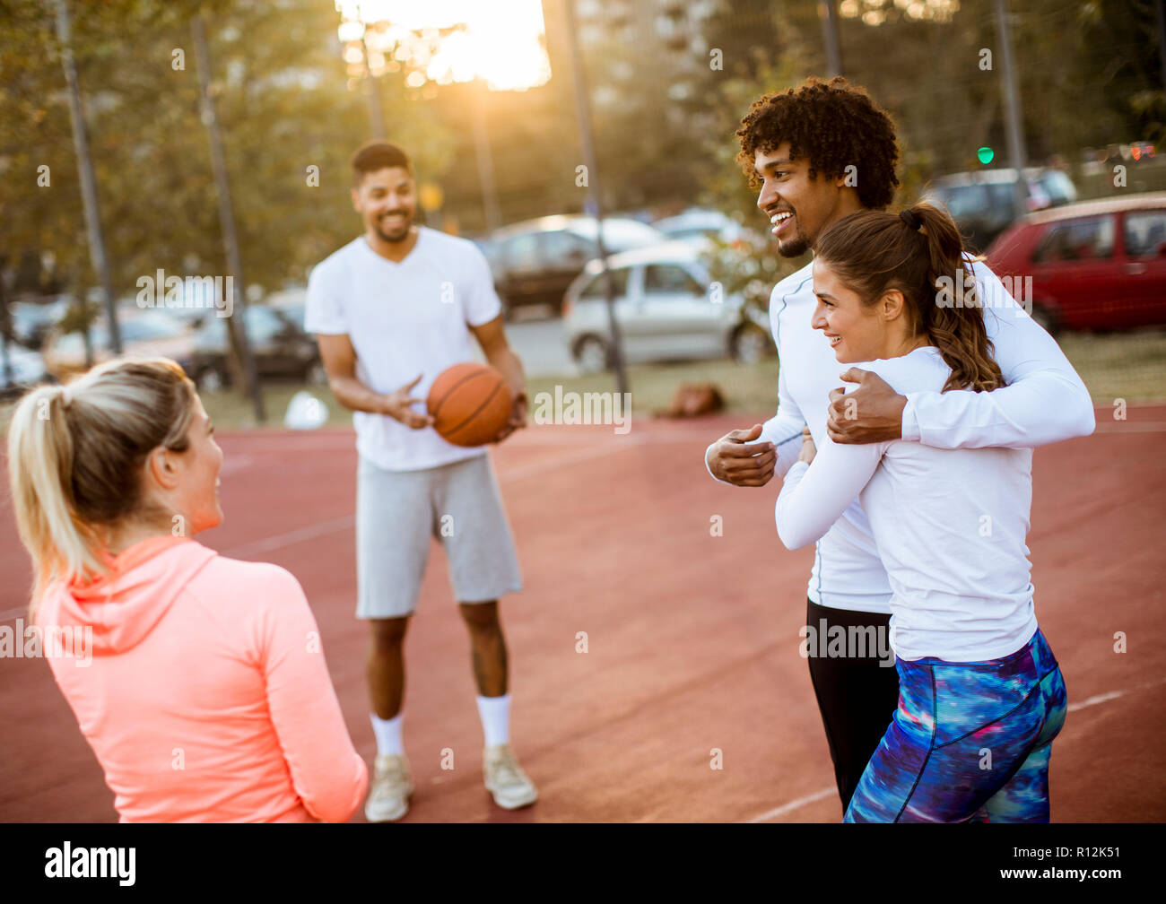 Group of multiethnic young people playing basketball on court Stock ...