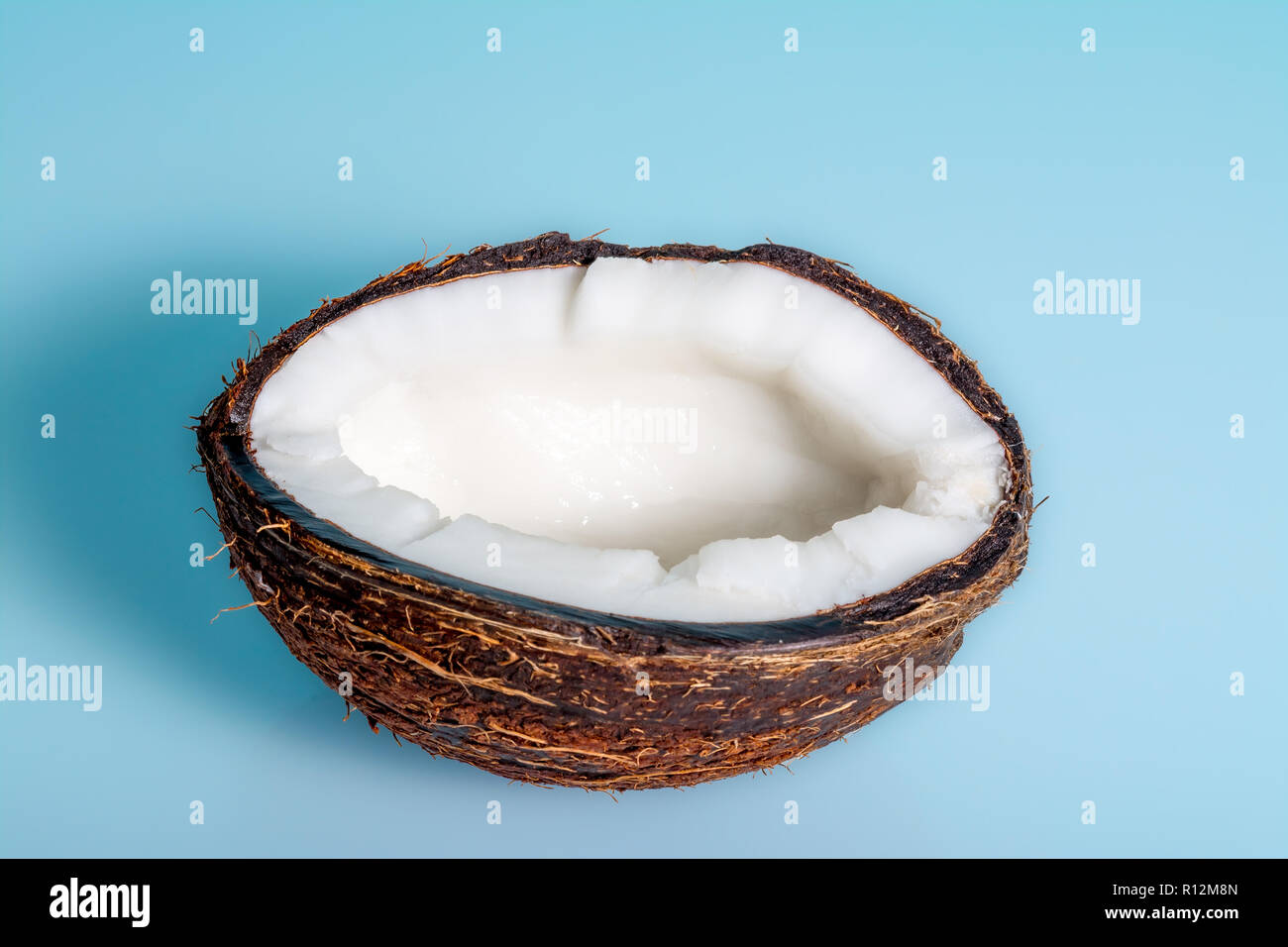 Crash coconut on a blue background close-up Stock Photo - Alamy