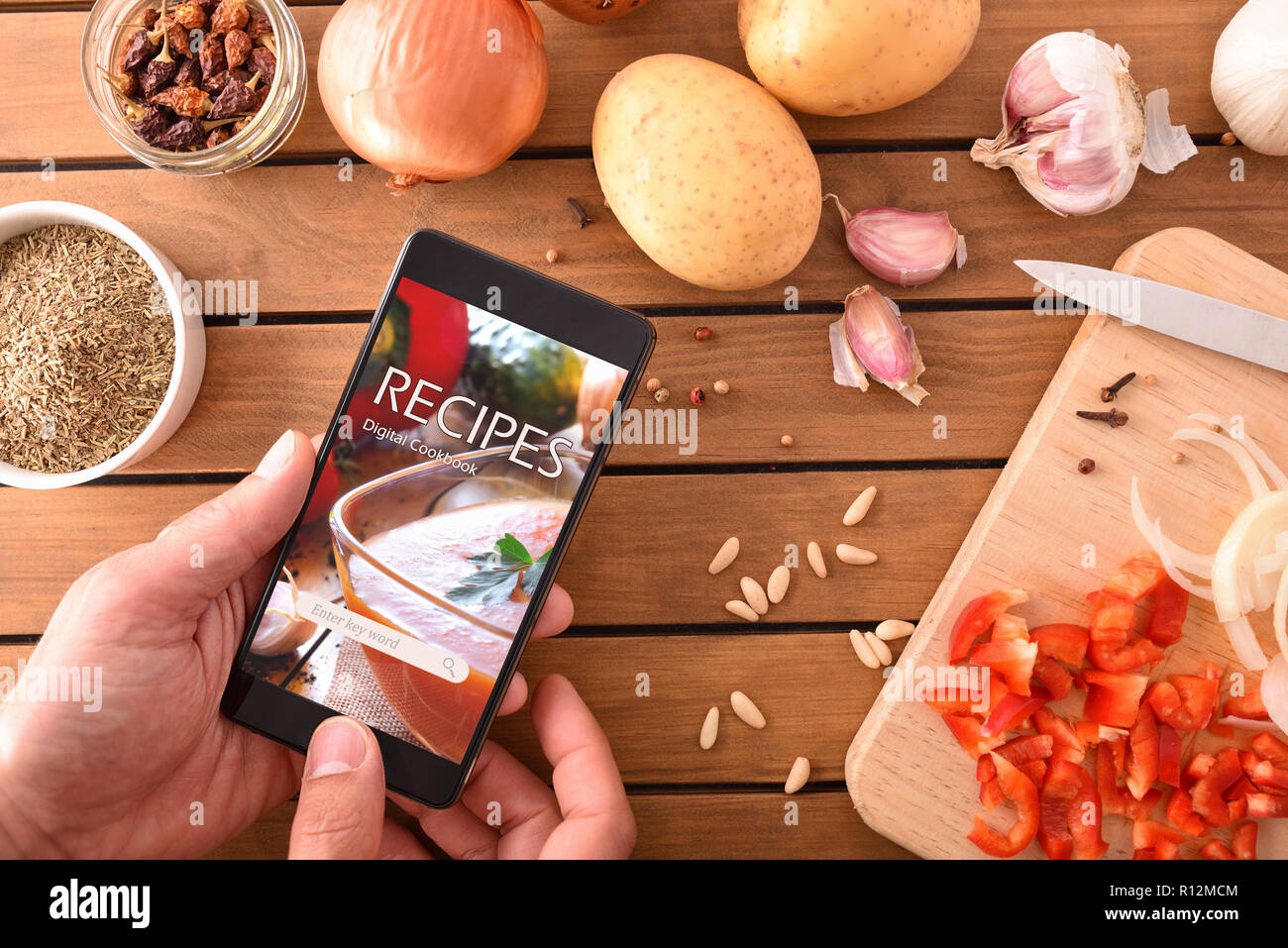 Smartphone with online recipes app and ingredients background. Use of ...
