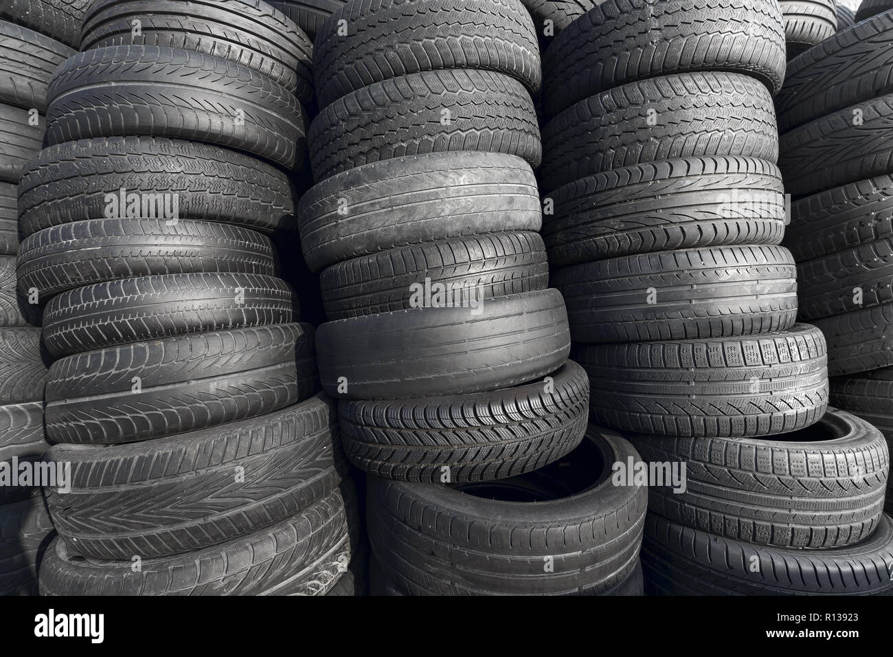 Pile of rubber automotive tyres, car tyres recycling background ...