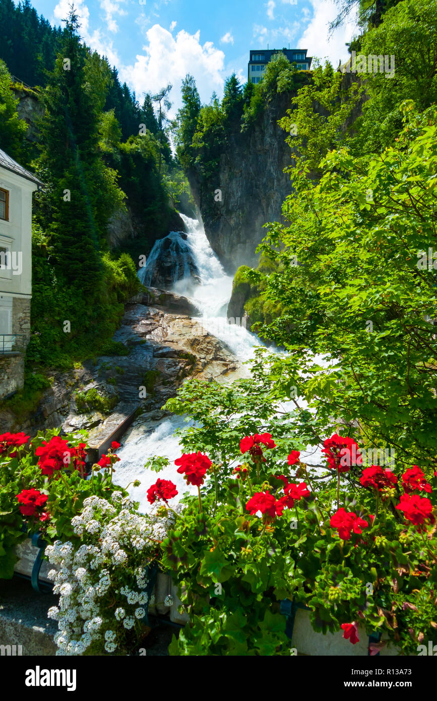 Flowers framing the Gasteiner Ache creating the Bad Gastein waterfall ...
