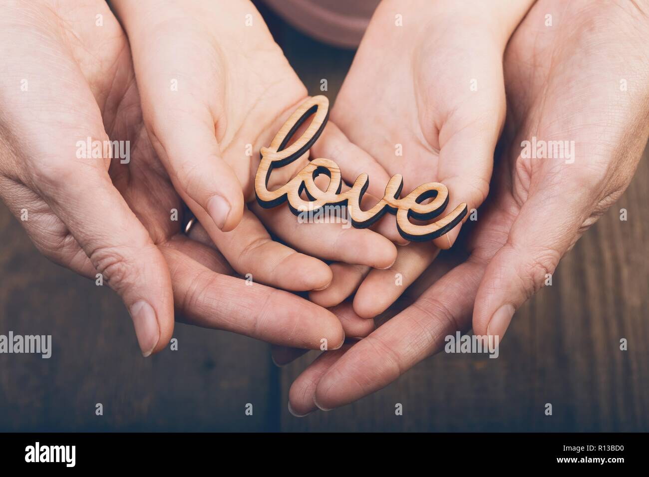 concept of family values - hands holding word love Stock Photo - Alamy