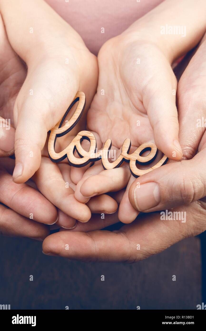 concept of family values - hands holding word love Stock Photo - Alamy