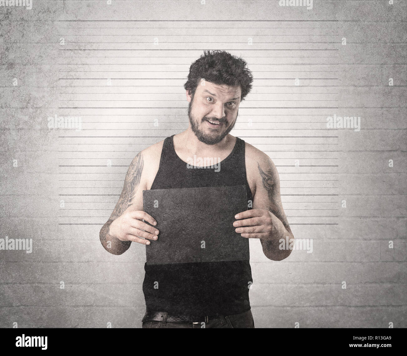 Gangster in front of a wall with table on his hand Stock Photo - Alamy