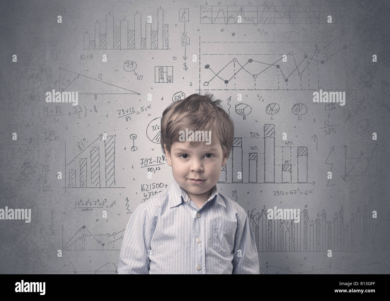 Little boy in front of a grey wall with graphs and statistics around ...