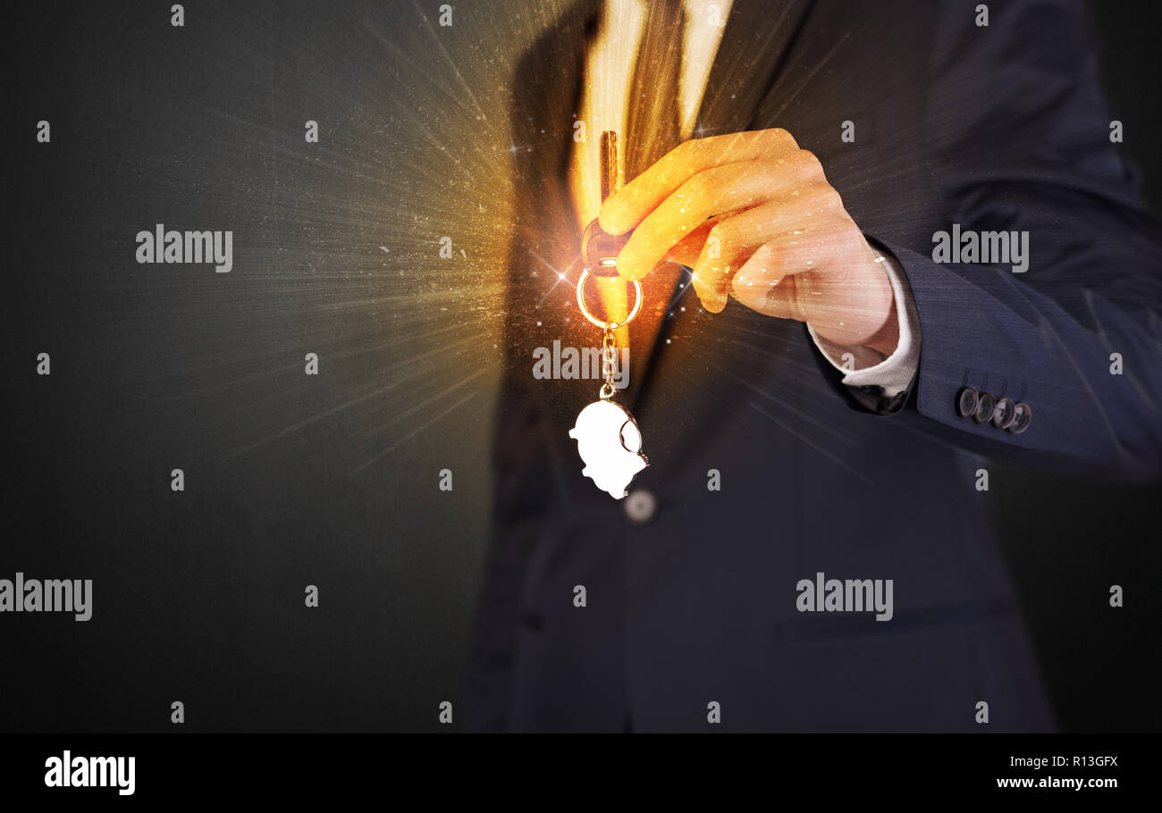 Formal man hand over shiny keys with dark background Stock Photo - Alamy