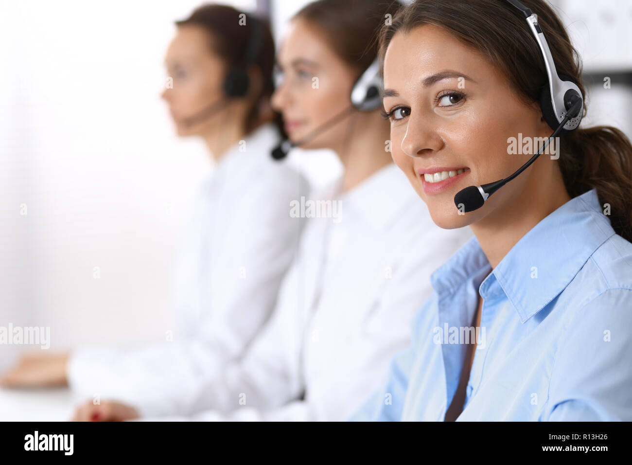 Call center. Group of operators at work. Focus on beautiful business woman in headset Stock ...