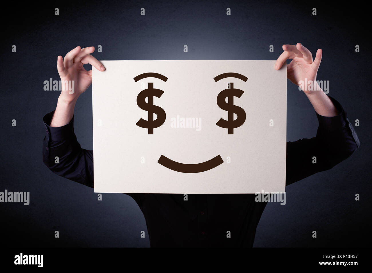 Young casual businessman hiding behind a greedy face drawing on ...