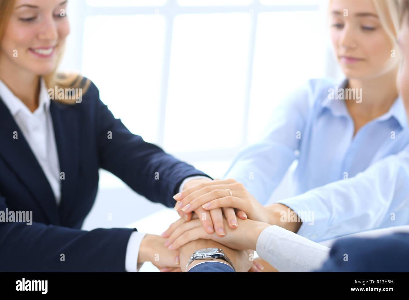 Business team showing unity with their hands together. Group of people joining hands and ...