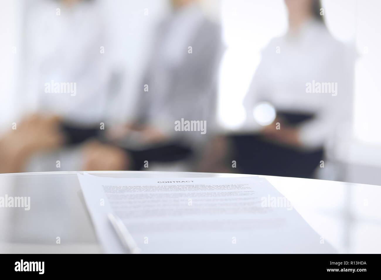 Contract with a pen and blurred business people on the background ...
